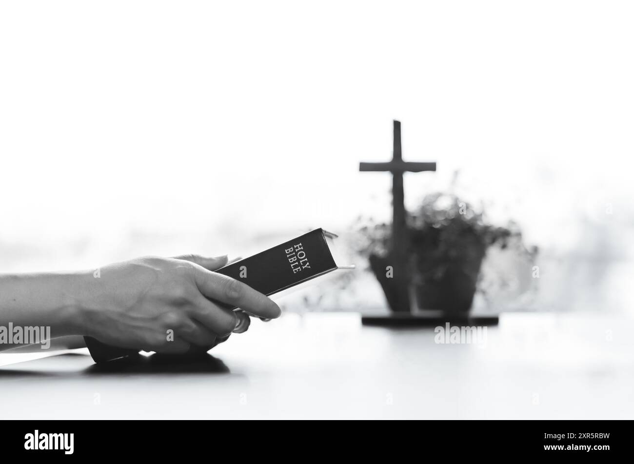 Christian praying and worshiping with holy bible in hand, cross of ...