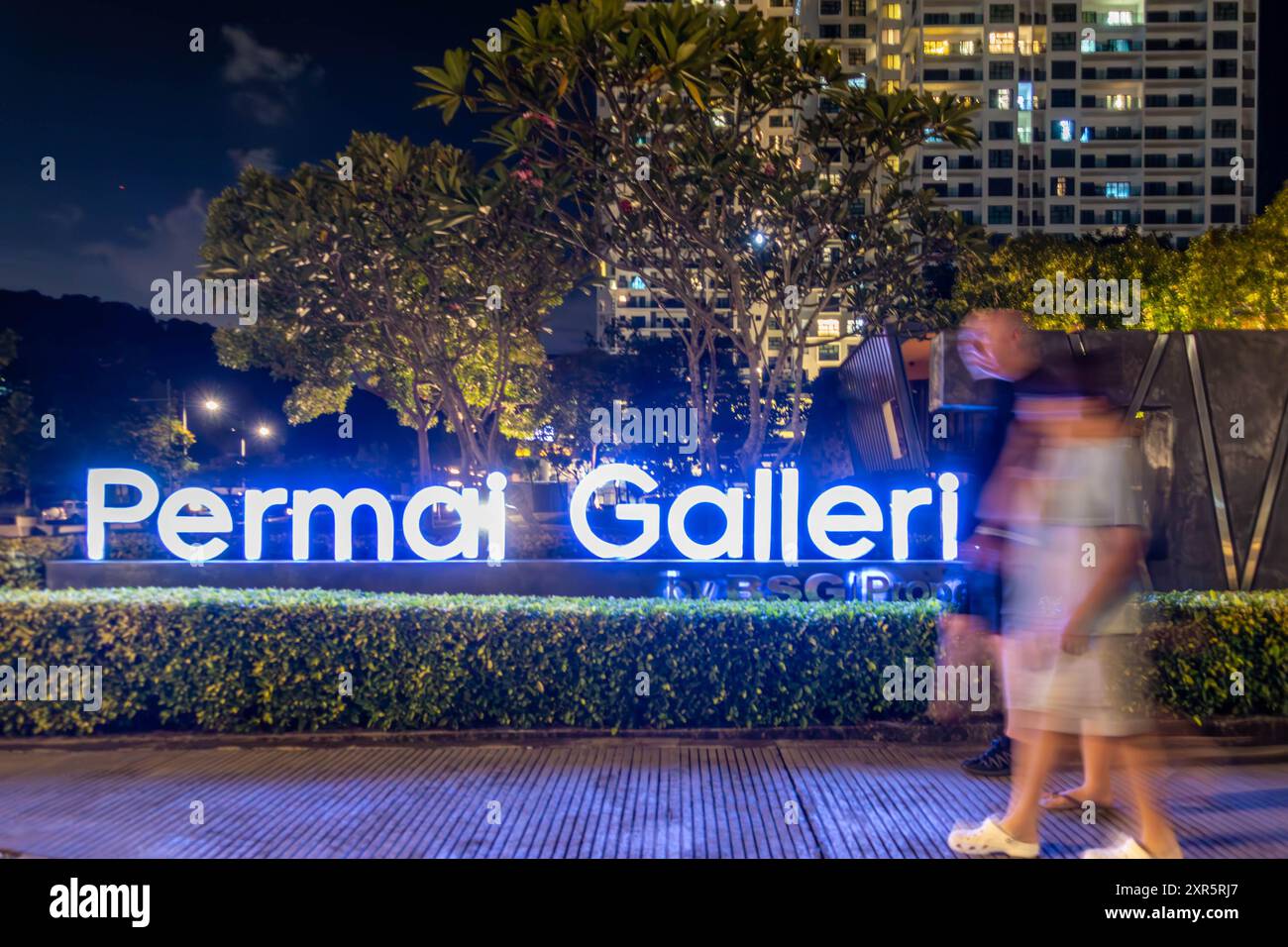 A neon white and blue Permain Galleria sign glows at night in Penang ...