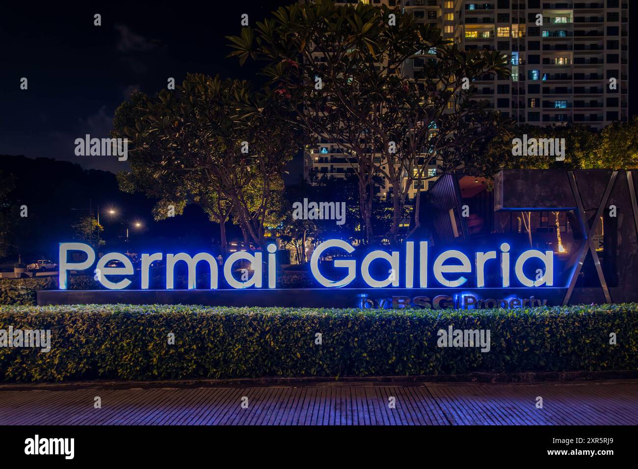 A neon white and blue Permain Galleria sign glows at night in Penang ...