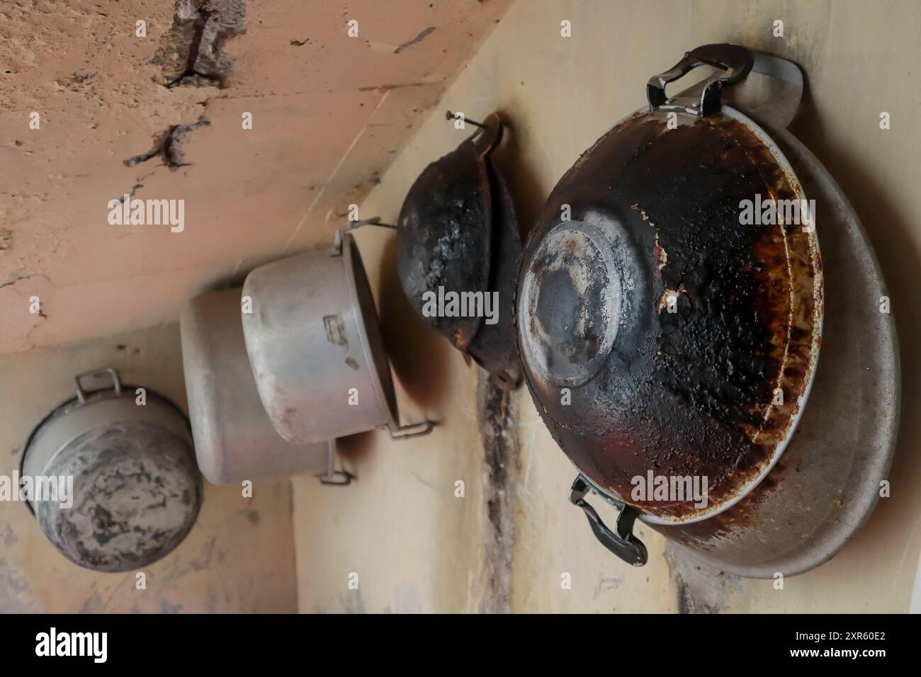 Dirty and crusty wok pan with burnt bottom. And some pan hanging on the ...