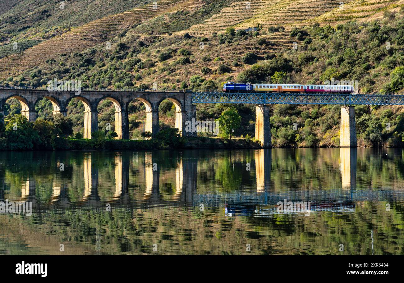 historic train on a bridge of the douro line in the middle of the port ...