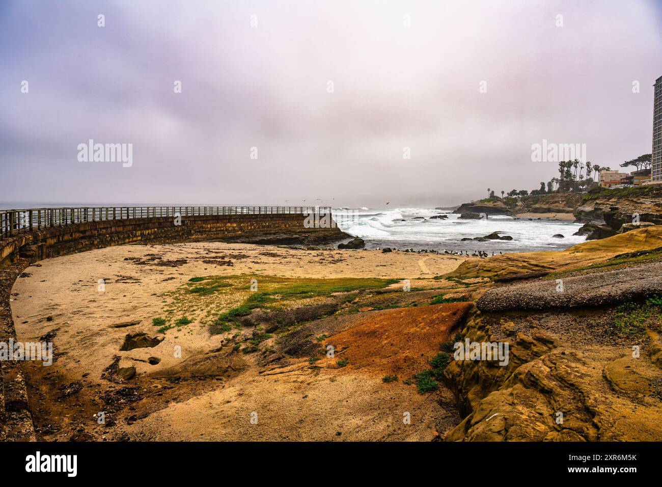 A scenic view of La Jolla Cove with a sandy beach, rocky shoreline, and ...