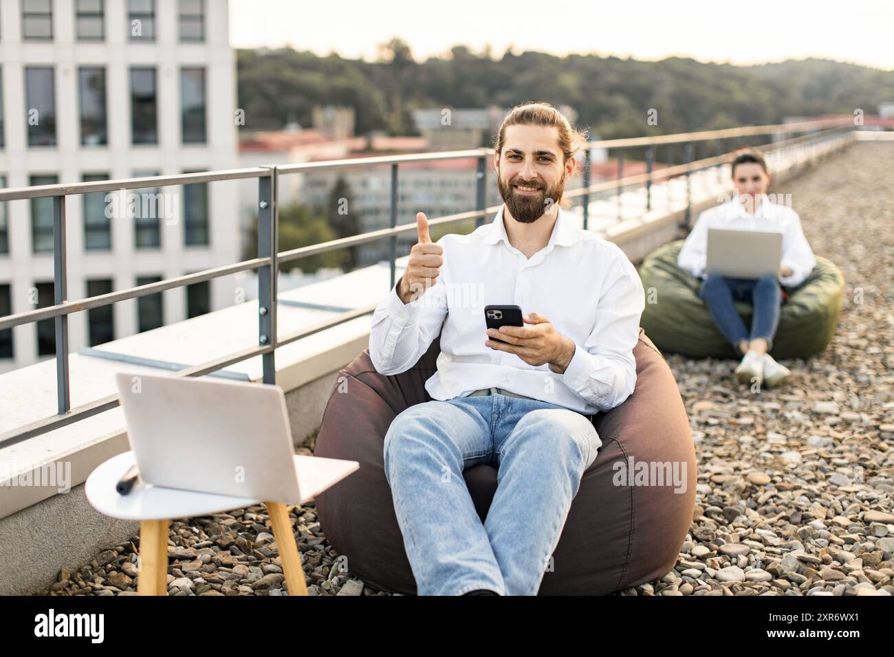 Outdoor office workers enjoying remote work on rooftop terrace Stock ...