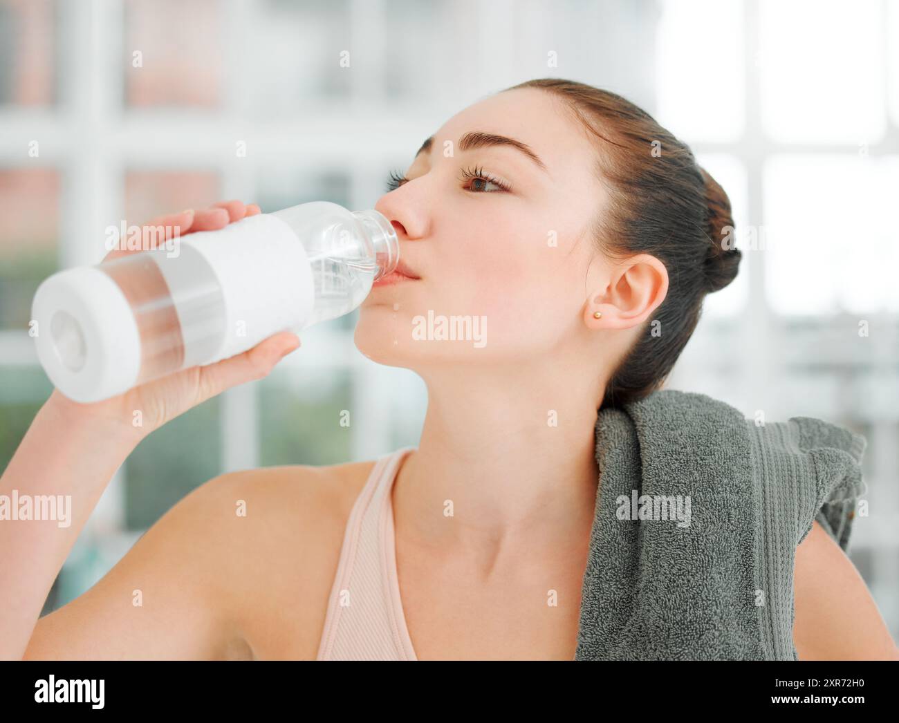 Fitness, drinking water and girl in gym with towel, hydration and break ...