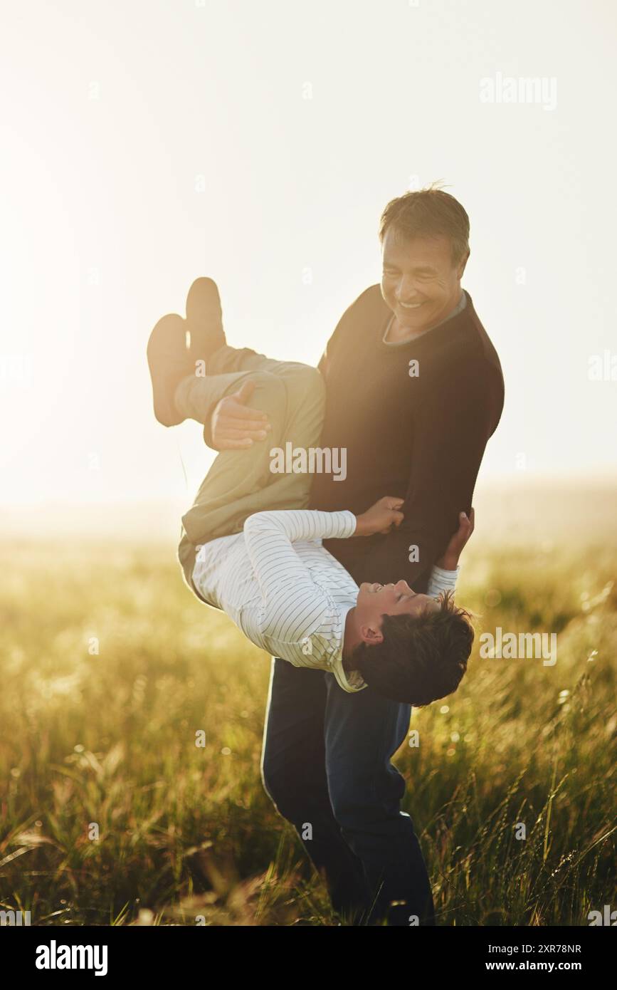 Playful, dad and carrying child by field with laugh for outdoor ...