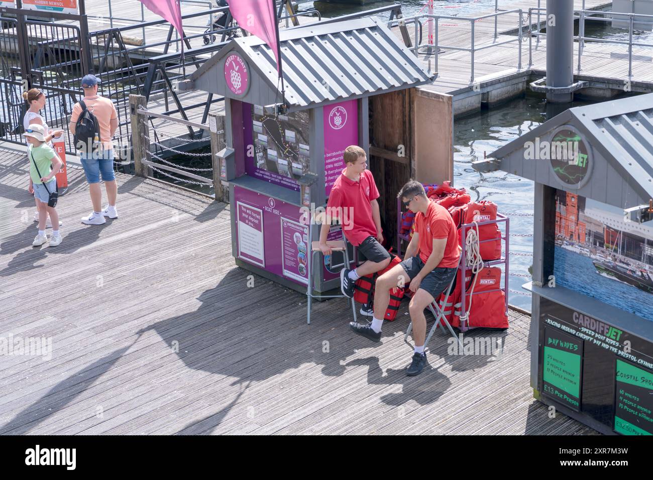 Boat staff and a family wait for the return of the boat at Boarding ...