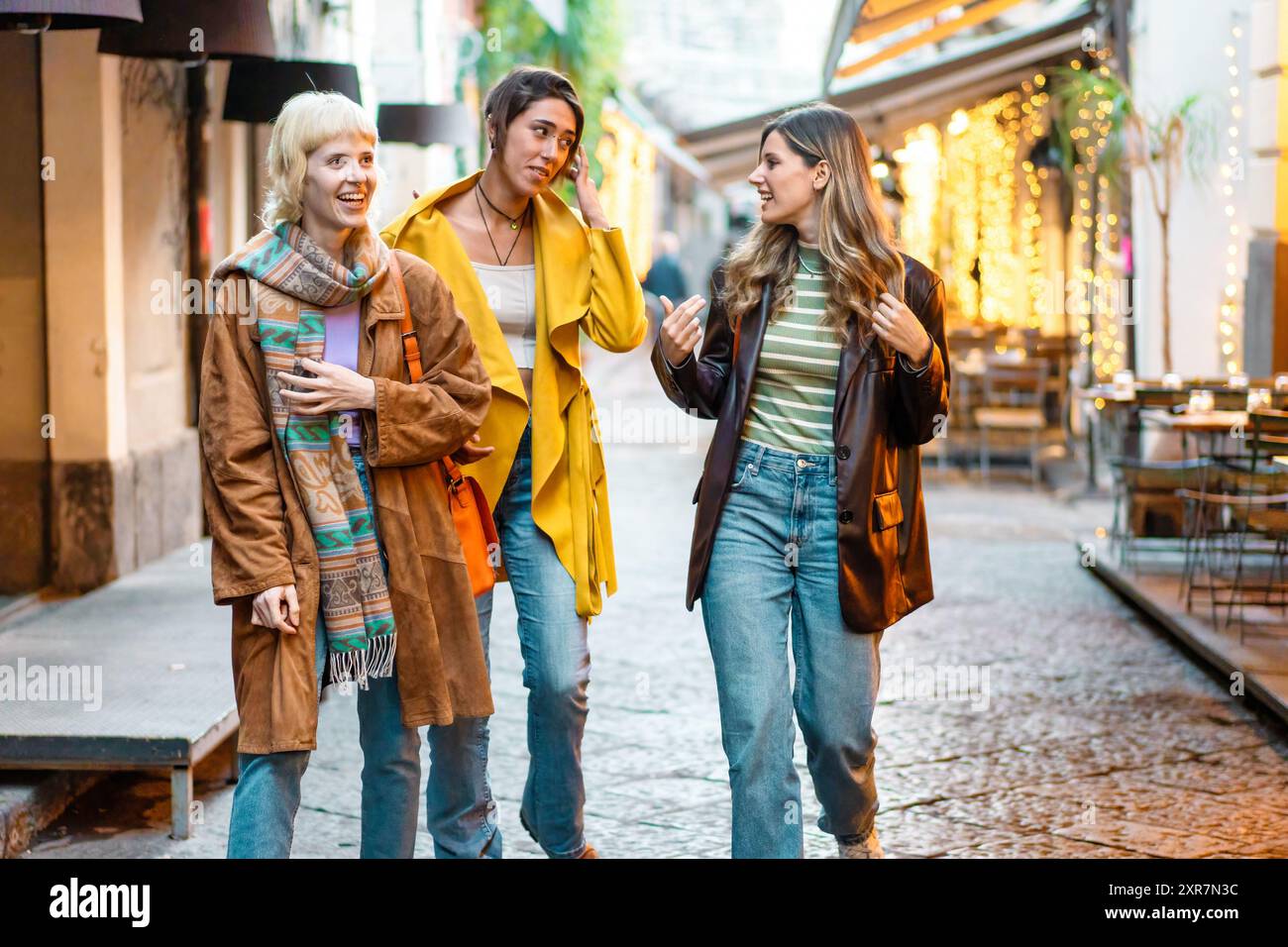 Three stylish young women of different ethnicities enjoying a walk in a ...