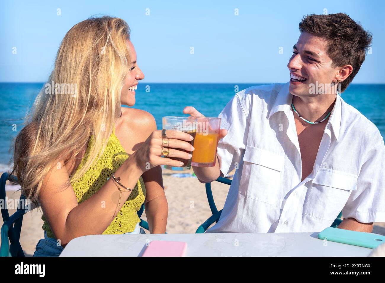 Happy young couple on vacation,drinking in restaurant Stock Photo - Alamy