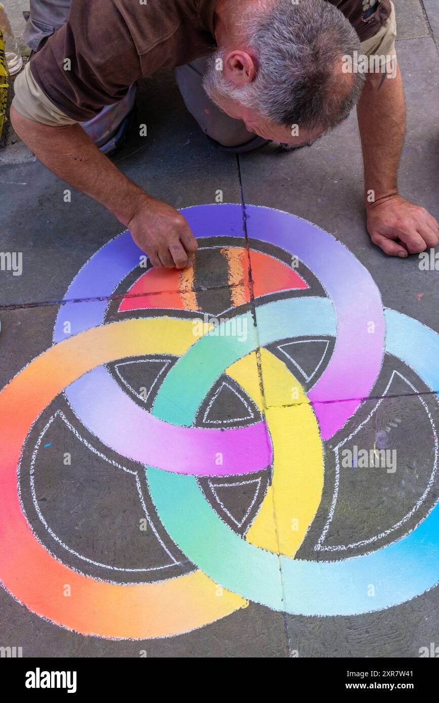 Male Street artist drawing a 'chalk mandala'- Borromean rings ...