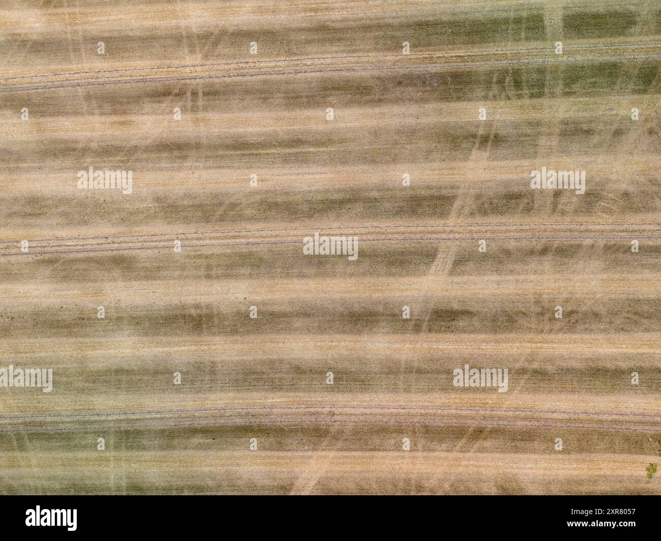 Agricultural background featuring parallel lines of tractor tracks in a ...