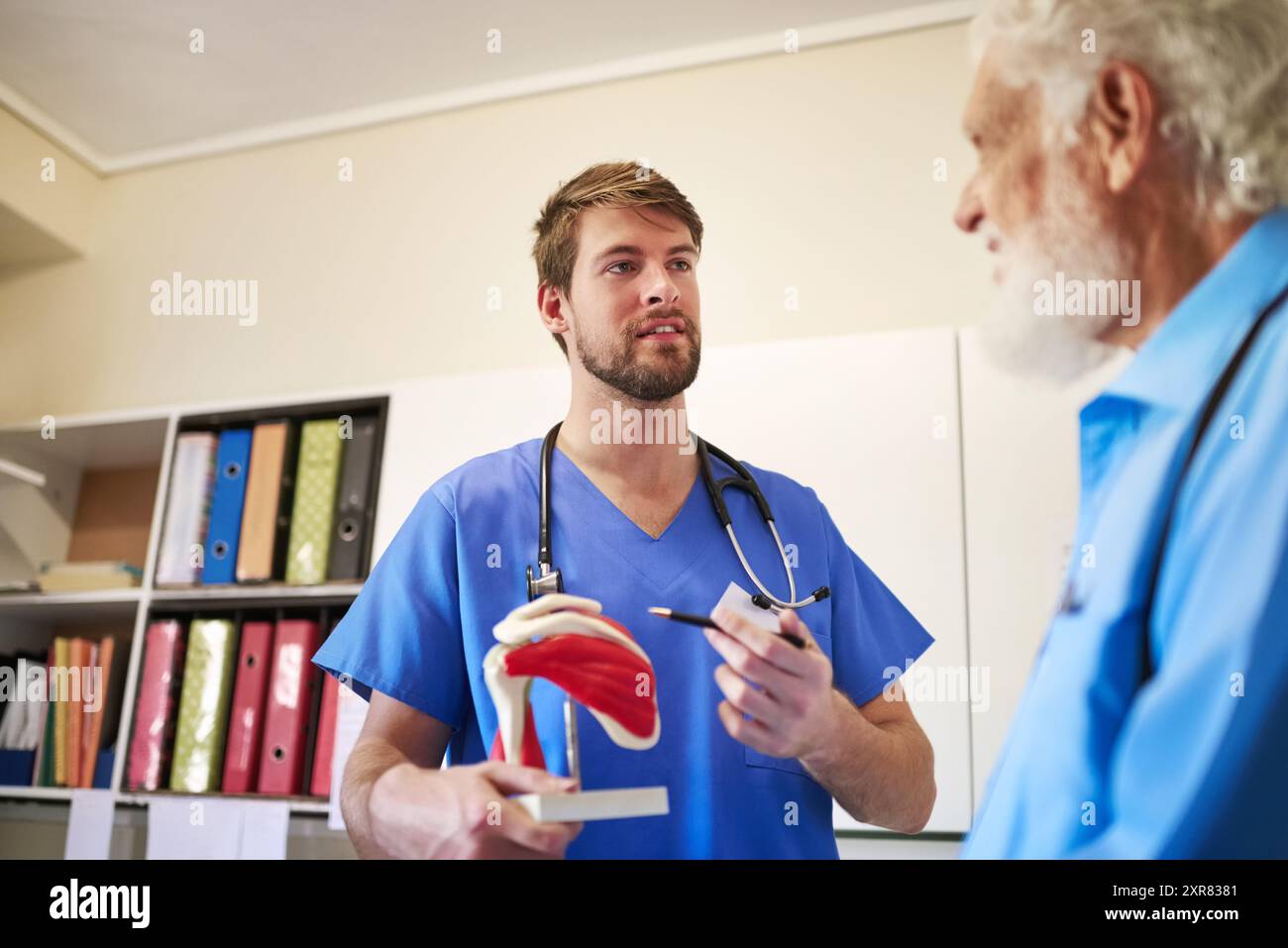 Muscle, model and doctor with mature man for demonstration for surgery ...
