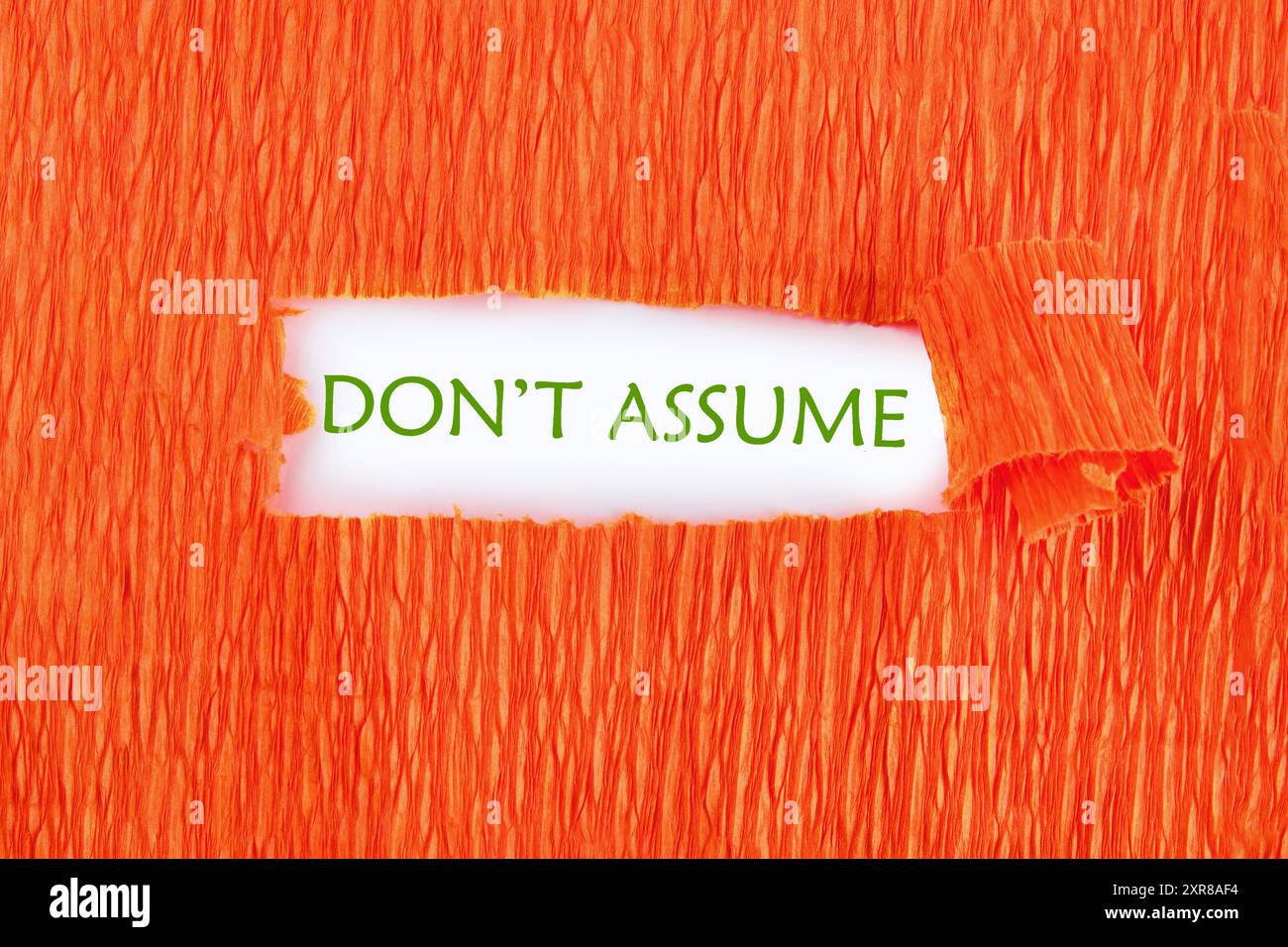 The words Don't Assume on white under the paper Stock Photo - Alamy