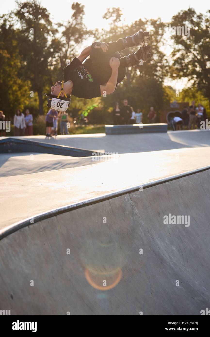 Roller performing a 540 bio mistyflip out of skate pool in skatepark ...