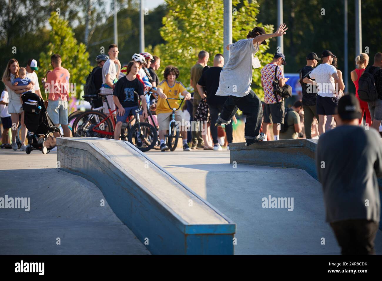 Young roller blader performing backslide grind on a ledge in skate park ...