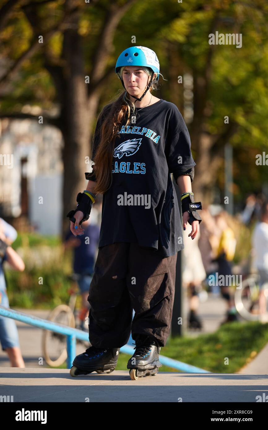 Young roller girl wearing aggressive in-line skates in a skatepark ...