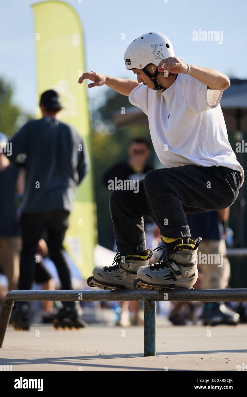 Inline rollerblader doing royale grind on a rail in skate park. Kyiv ...