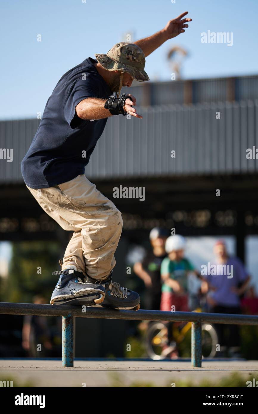 Inline skater doing unity grind on rail in skatepark. Kyiv - 4 August ...