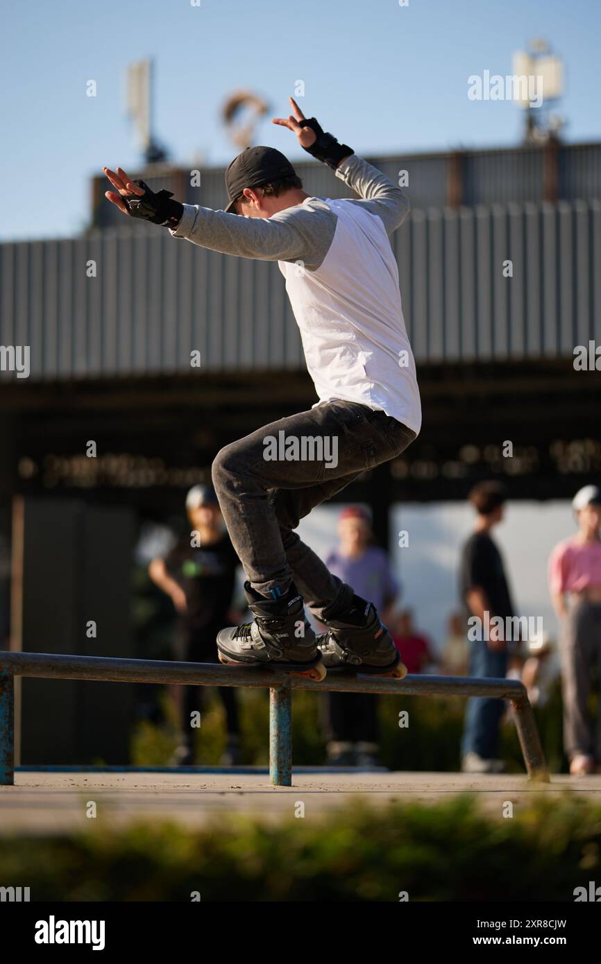 Roller doing royale grind on a rail in skate park. Kyiv - 4 August,2024 ...