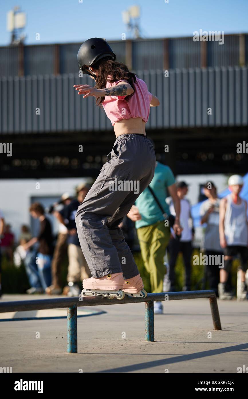 Roller girl doing royale grind on rail at skate contest in a park. Kyiv ...