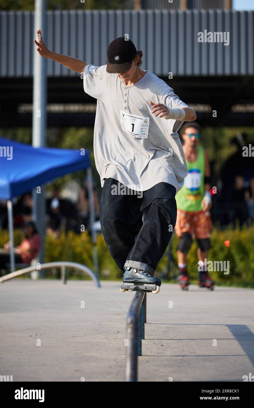 Roller doing acid soul grind on rail in a skate park in summer. Kyiv ...