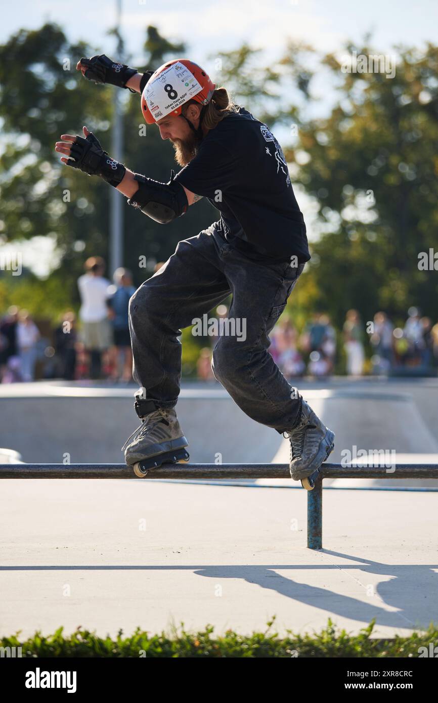 Roller blader doing bs full torque grind on a rail in skatepark. Kyiv ...