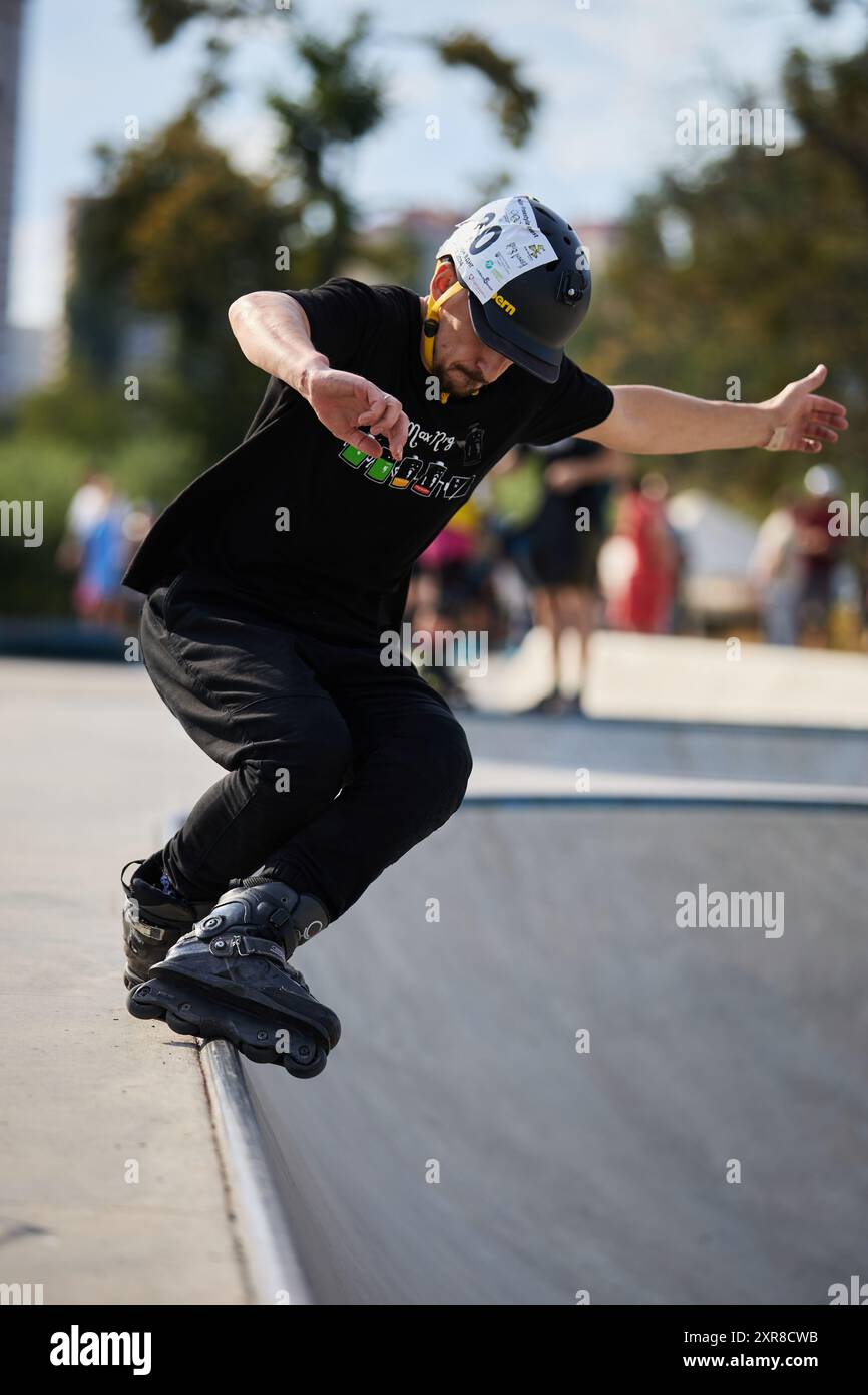 Roller grinding in a skate pool. Aggressive in-line skater performing ...