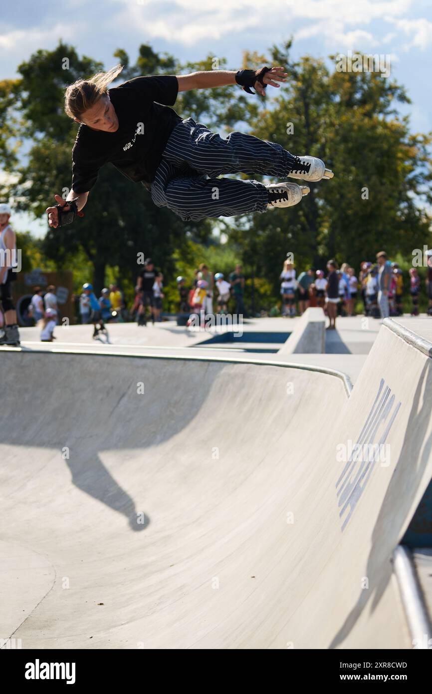 Roller blader jumping high in a skate pool. Inline skater performing ...
