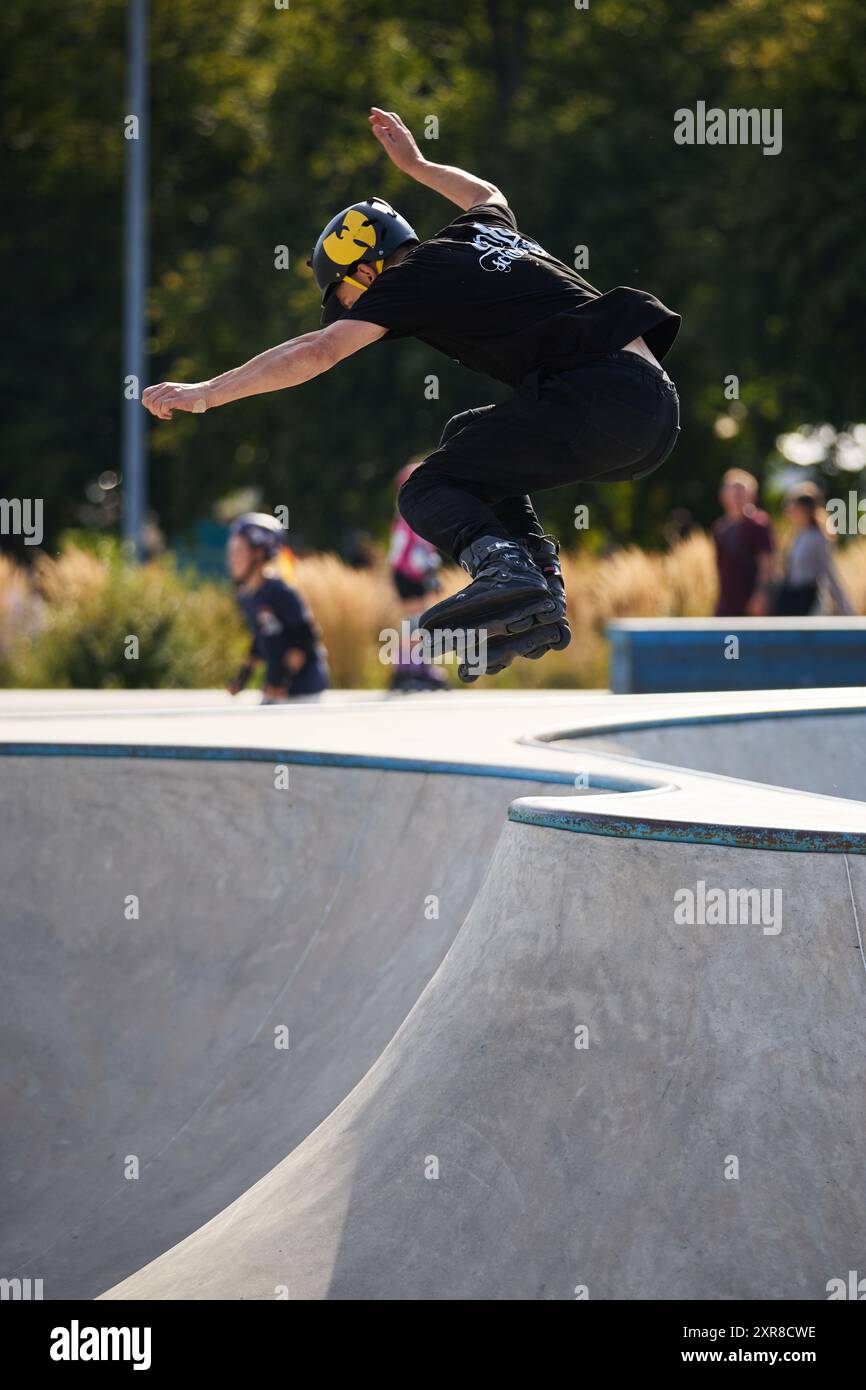 Roller skating in a skate pool. Aggressive inline skater jumping on a ...