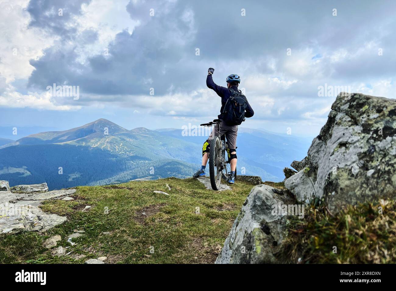 Cyclist man riding electric bike outdoors. Back view of male tourist ...