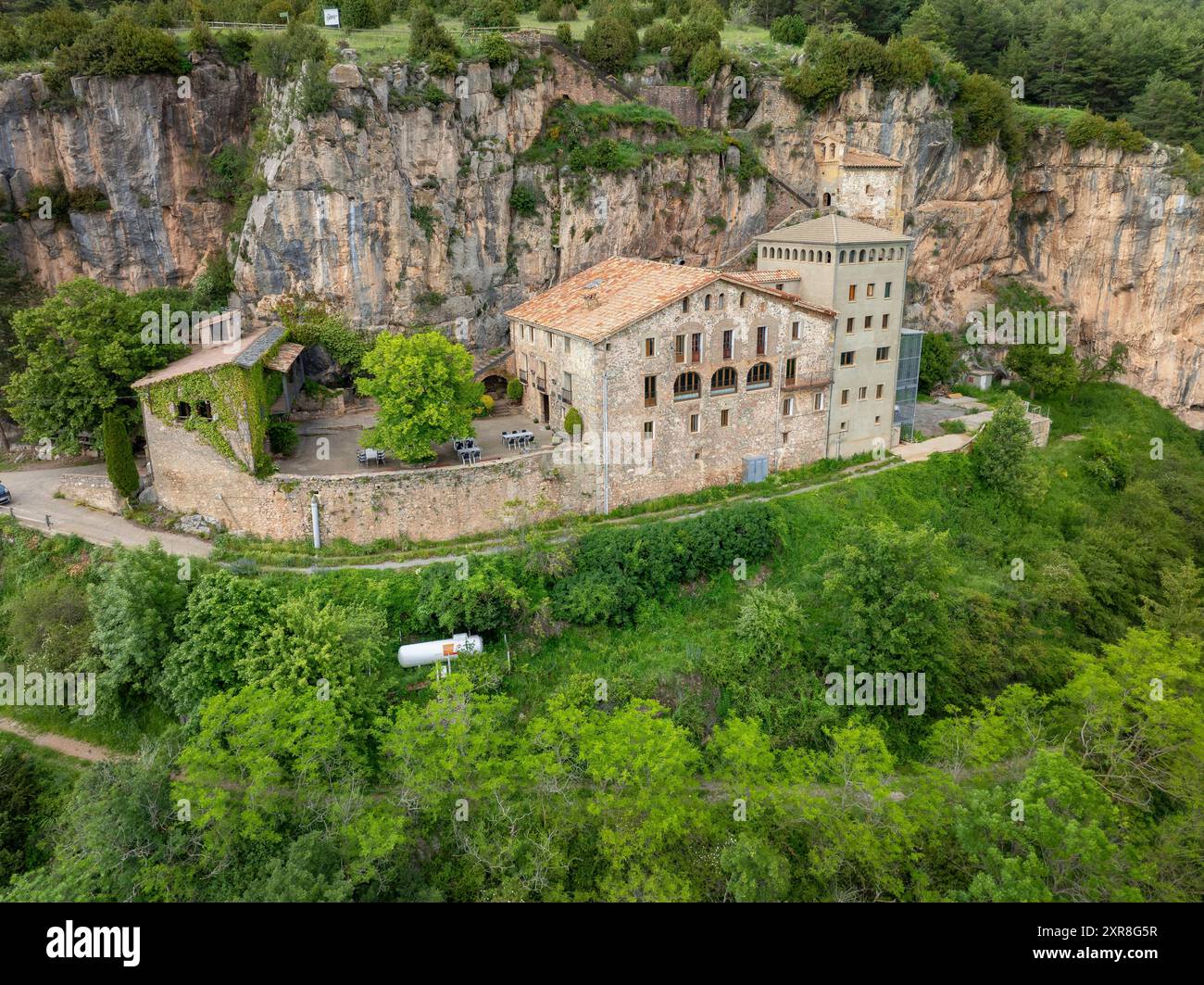 Aerial view of the Montgrony sanctuary built at the base of a cliff in ...