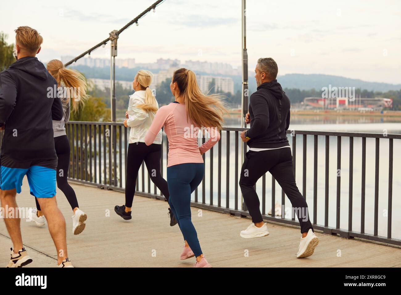 Team Of Athletes Running Together In City Park Stock Photo - Alamy