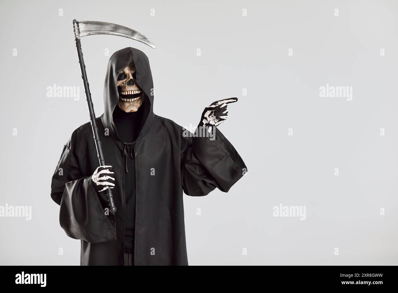 Man in Halloween grim reaper death costume pointing index finger to the ...