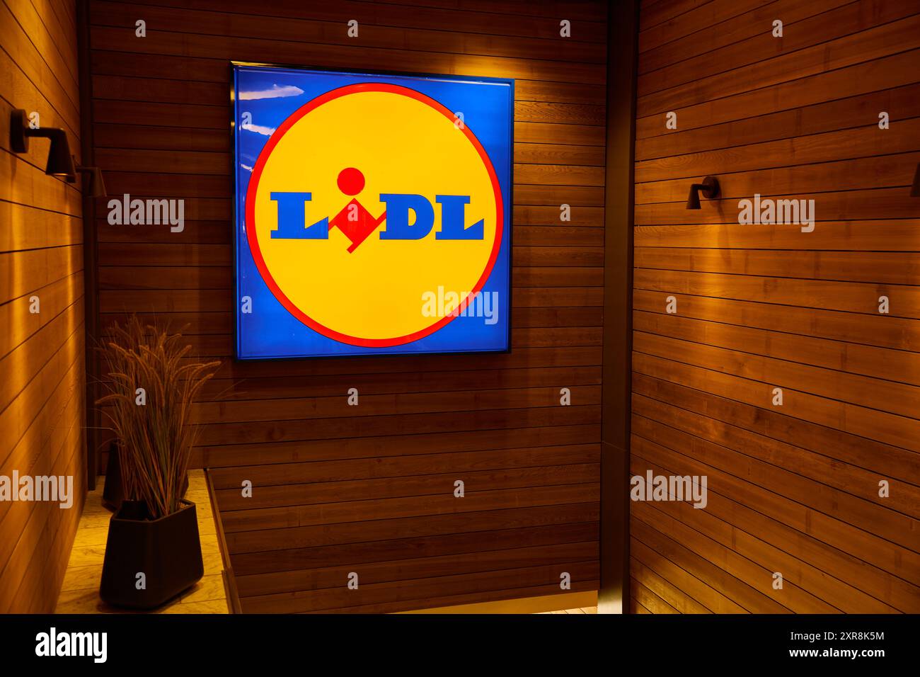 Illuminated Lidl logo inside store with wooden wall panels. German ...