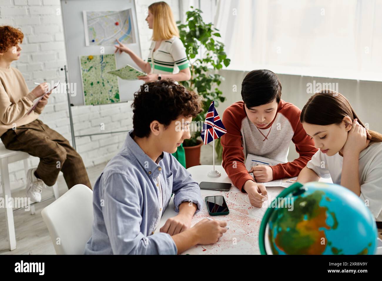 Teenagers working together on a map during a UN model conference Stock ...