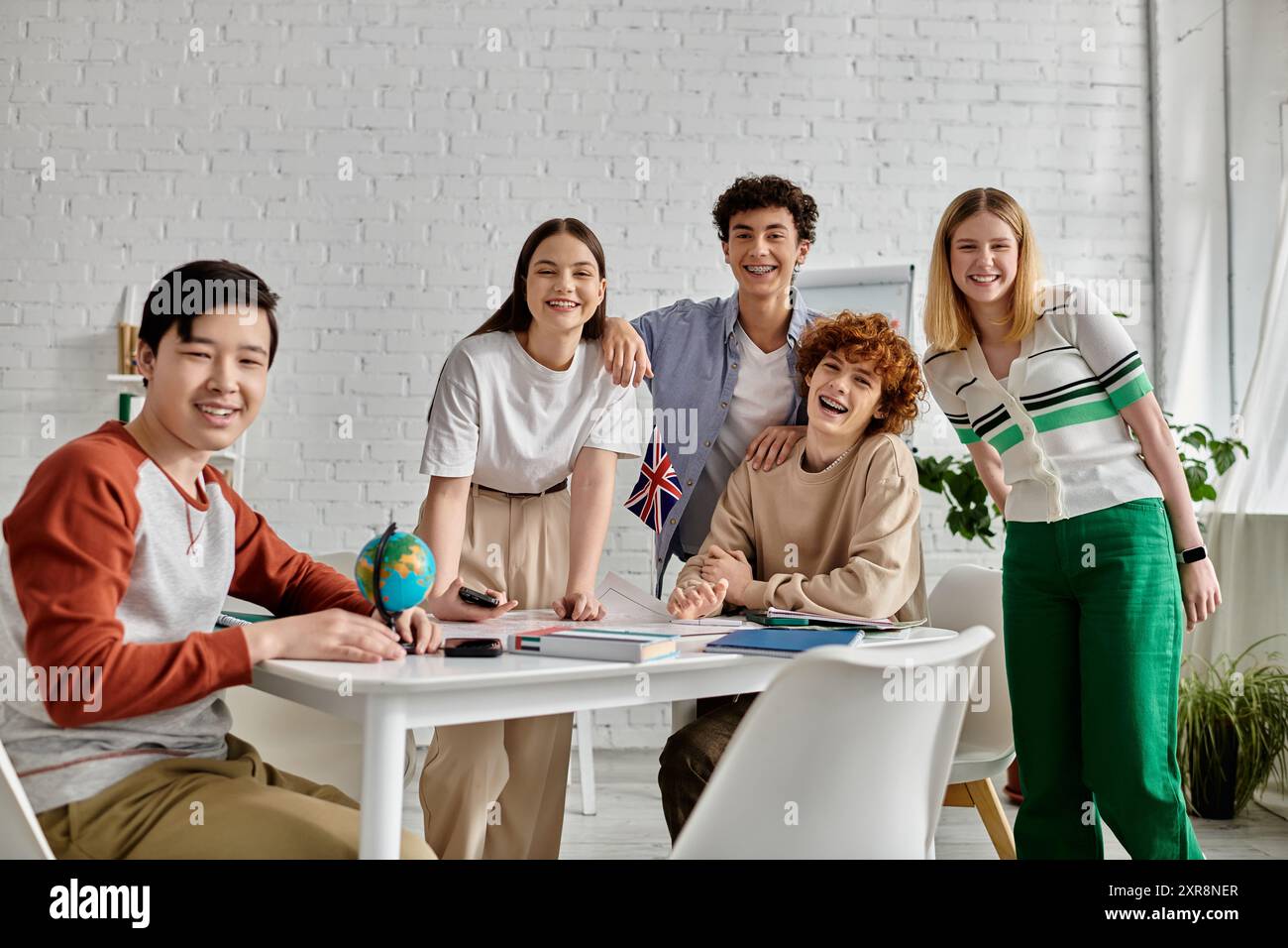 A group of teenagers in a classroom, smiling and preparing for a UN ...
