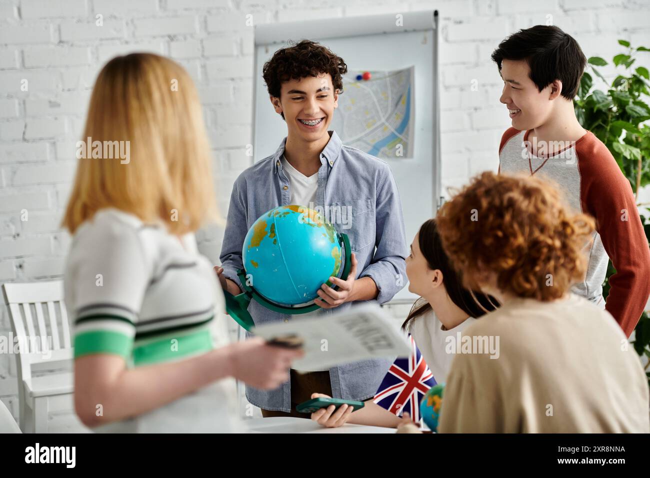 Teens use globe in animated UN Model talk Stock Photo - Alamy