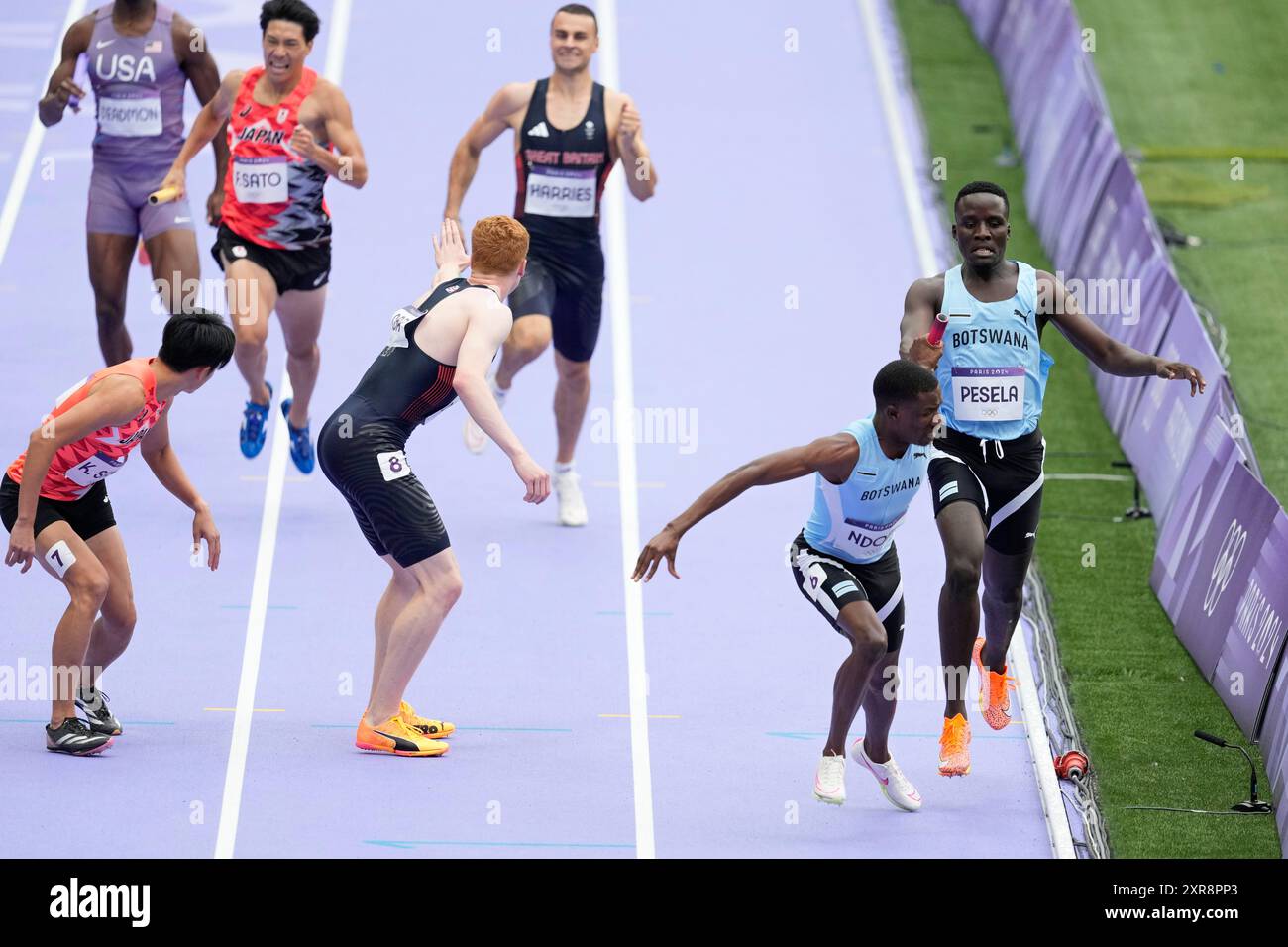Anthony Pesela, of Botswana, hands over the baton to teammate Bayapo ...