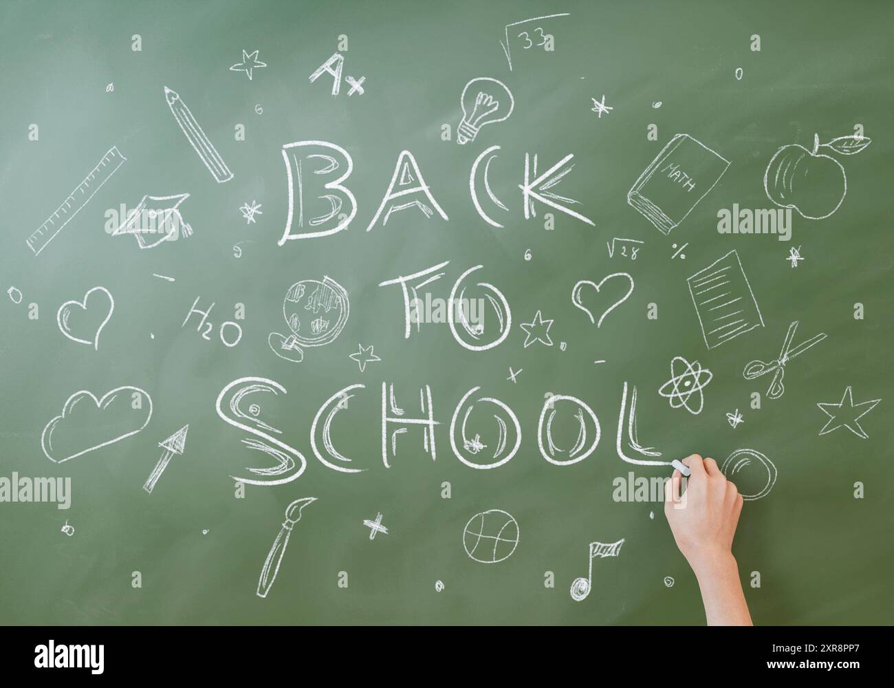 Hand drawing "Back to School" on a green chalkboard with various ...