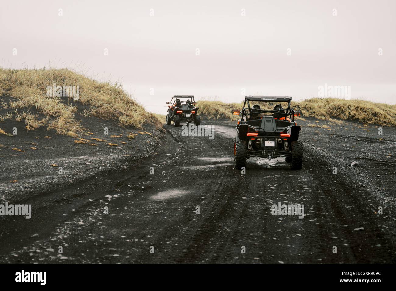 Buggy pair passing black volcanic sand dunes in rain Stock Photo - Alamy