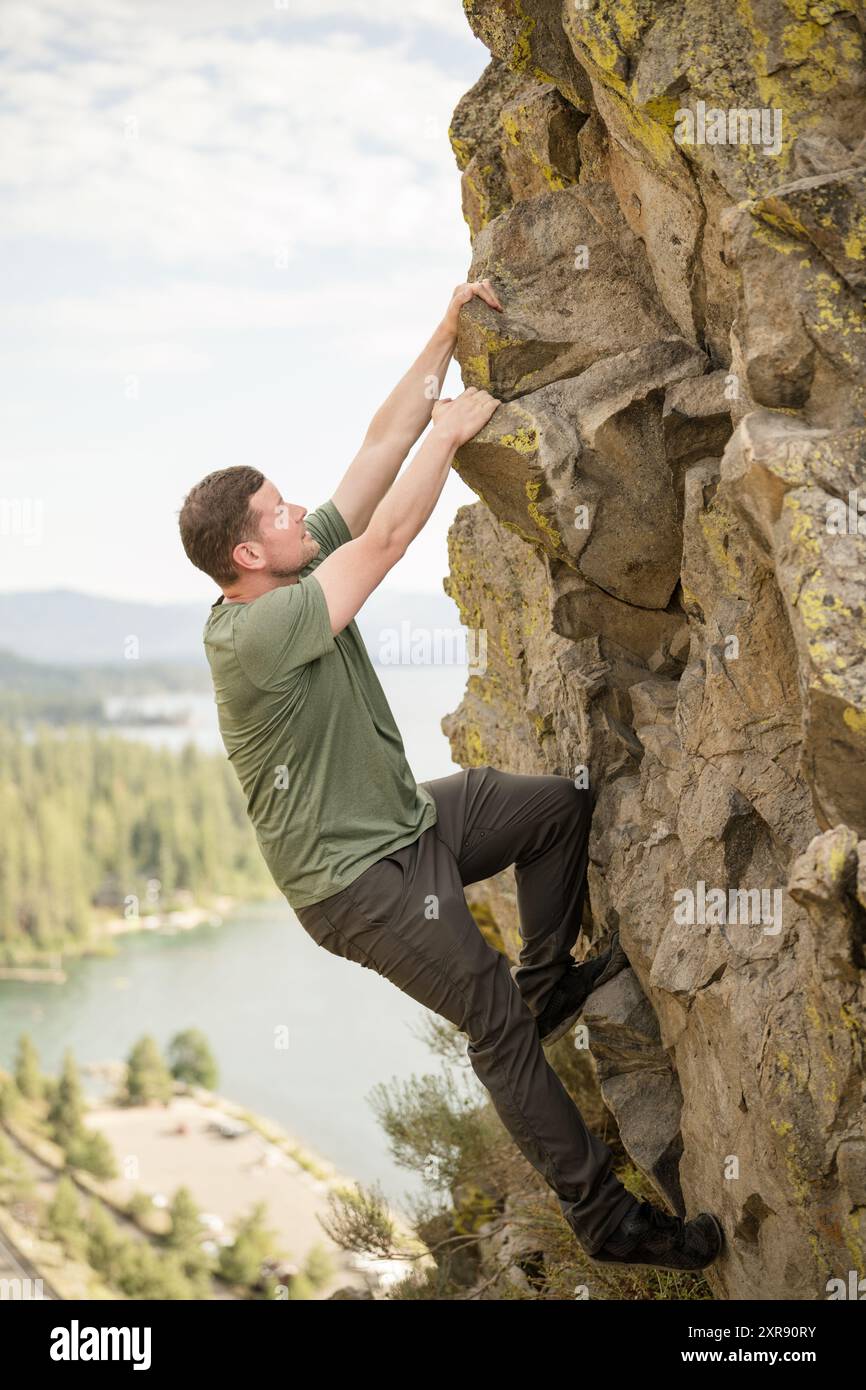 Man climbing a cliff with scenery behind Stock Photo - Alamy
