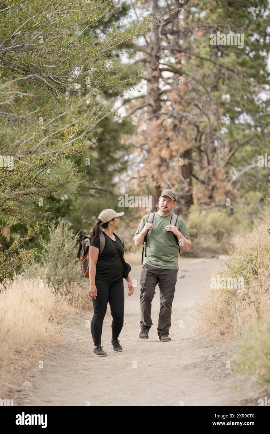 Couple walking down trail together in woods Stock Photo - Alamy
