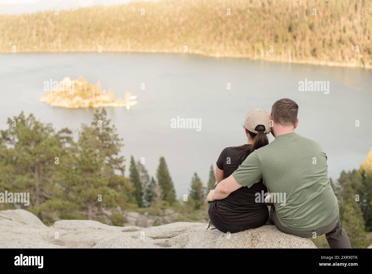 Couple sitting together with their arms around each other overlooking ...