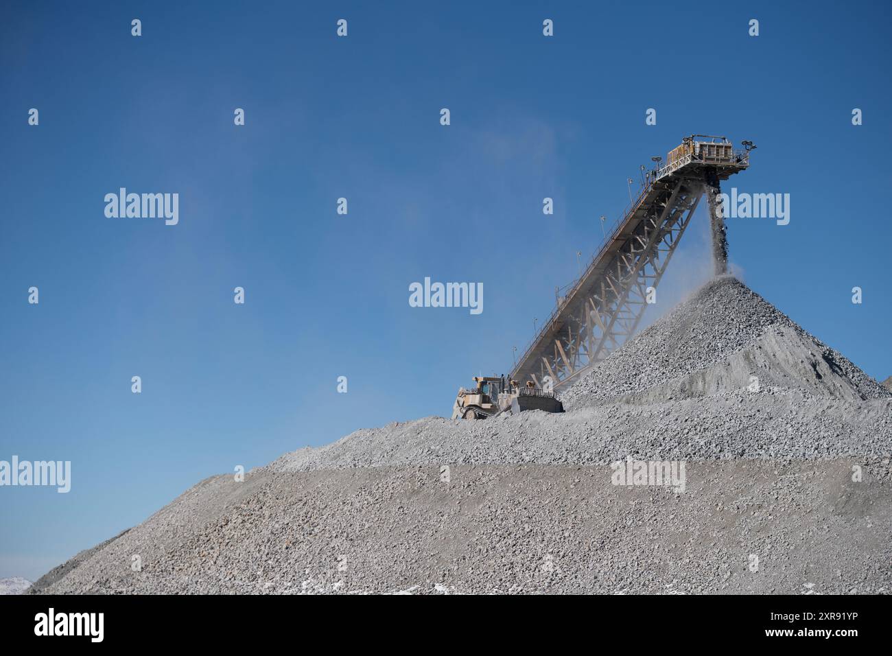 Industrial conveyor belt dumping rocks at a copper mine with bul Stock ...