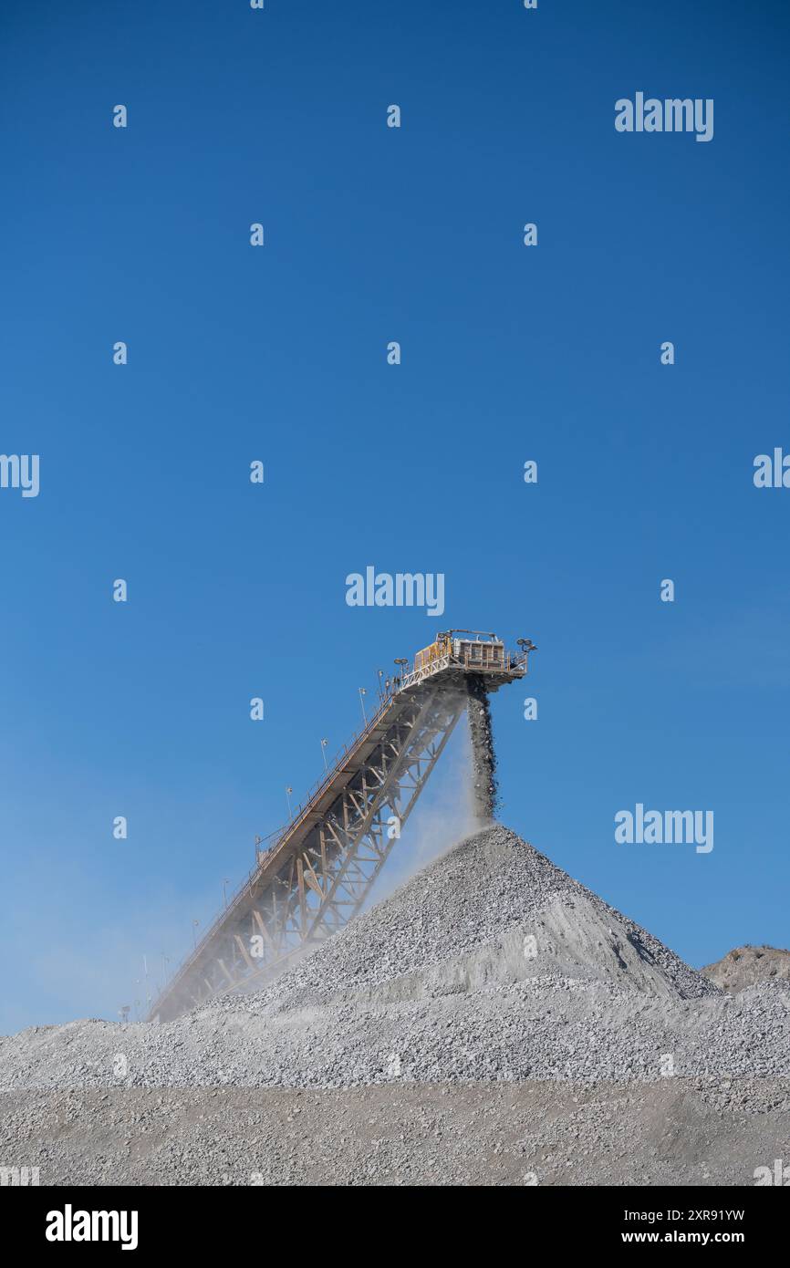 Industrial conveyor belt dumping rock debris at mine with brigh Stock ...