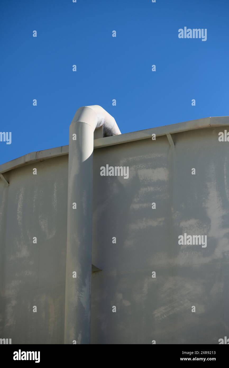 Pale green pipe and large scale water storage tank on a blue sky Stock ...