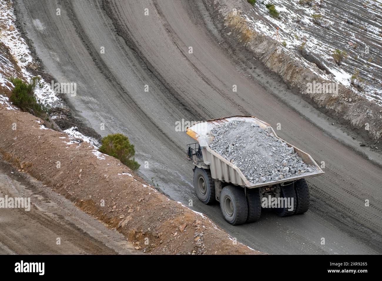 Large scale industrial dump truck full of rocks driving on a min Stock ...