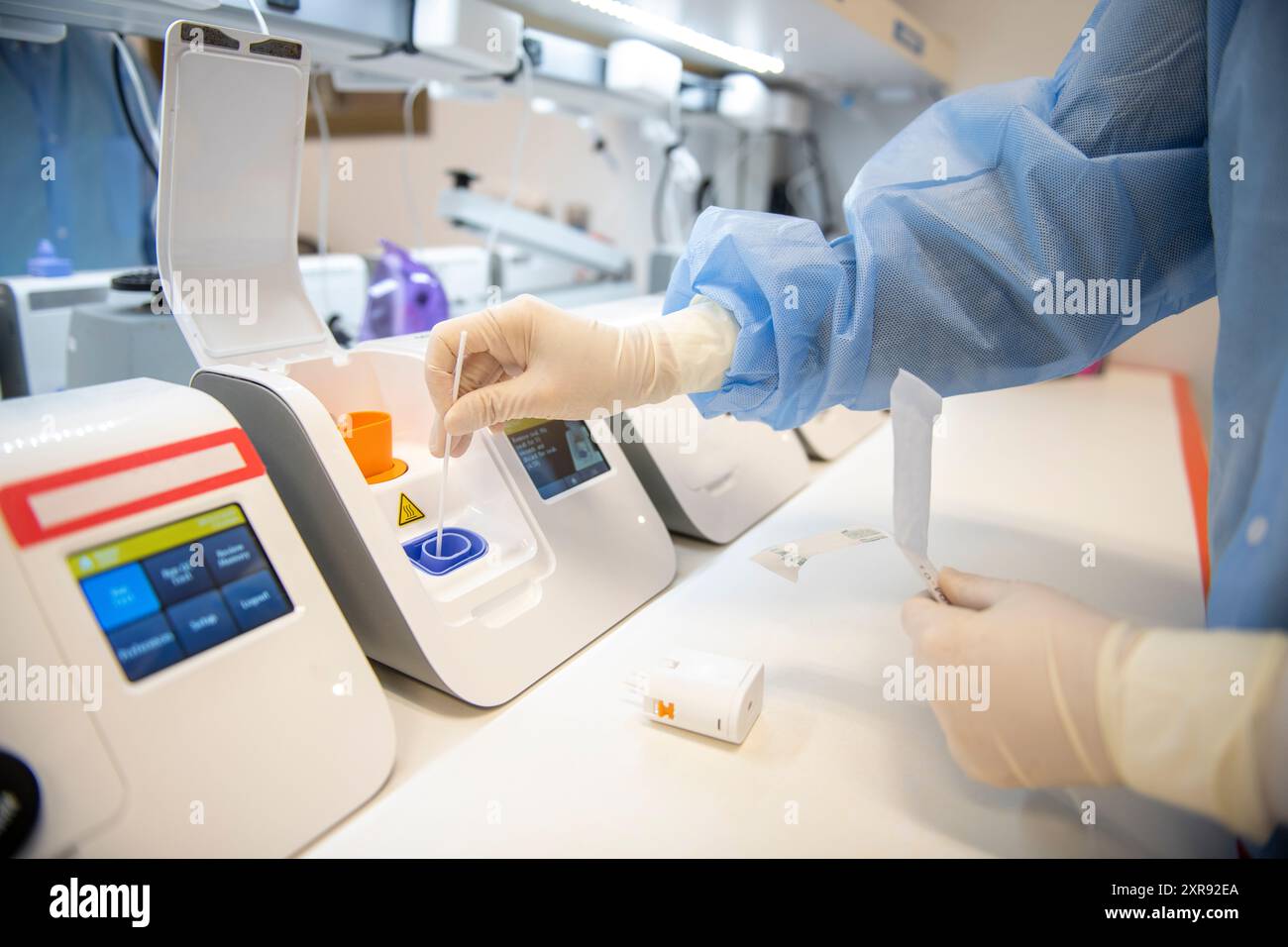 Lab technician placing swab stick into point-of-care testing mac Stock ...