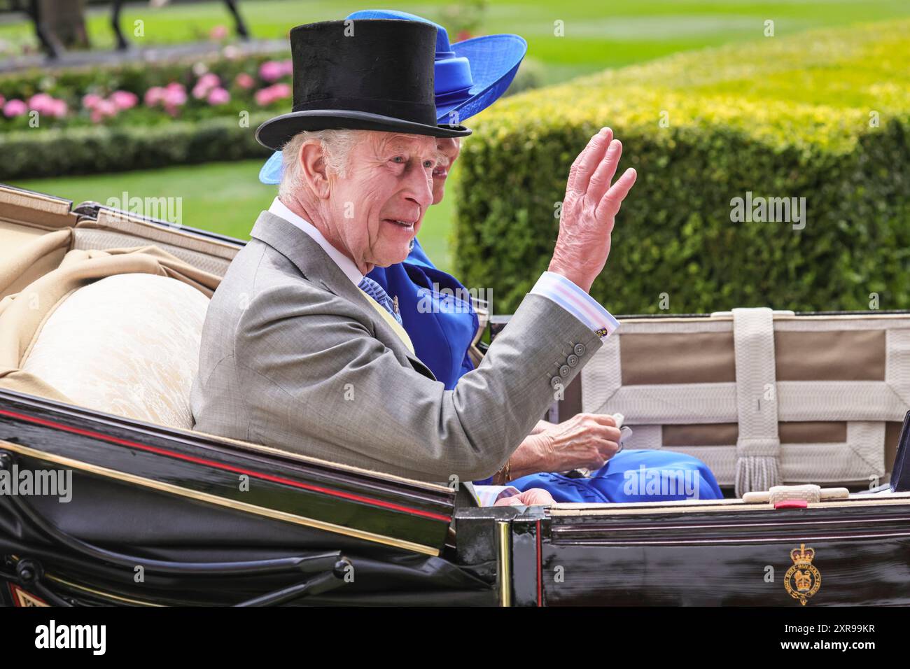 King Charles III, in top hat, smiles and waves from the carriage during ...