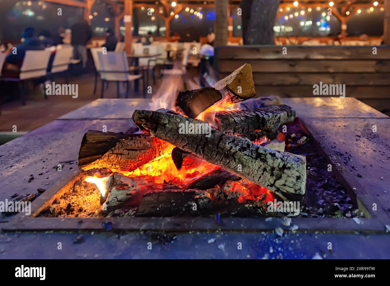 Log fireplace with burning wood in restaurant Stock Photo - Alamy