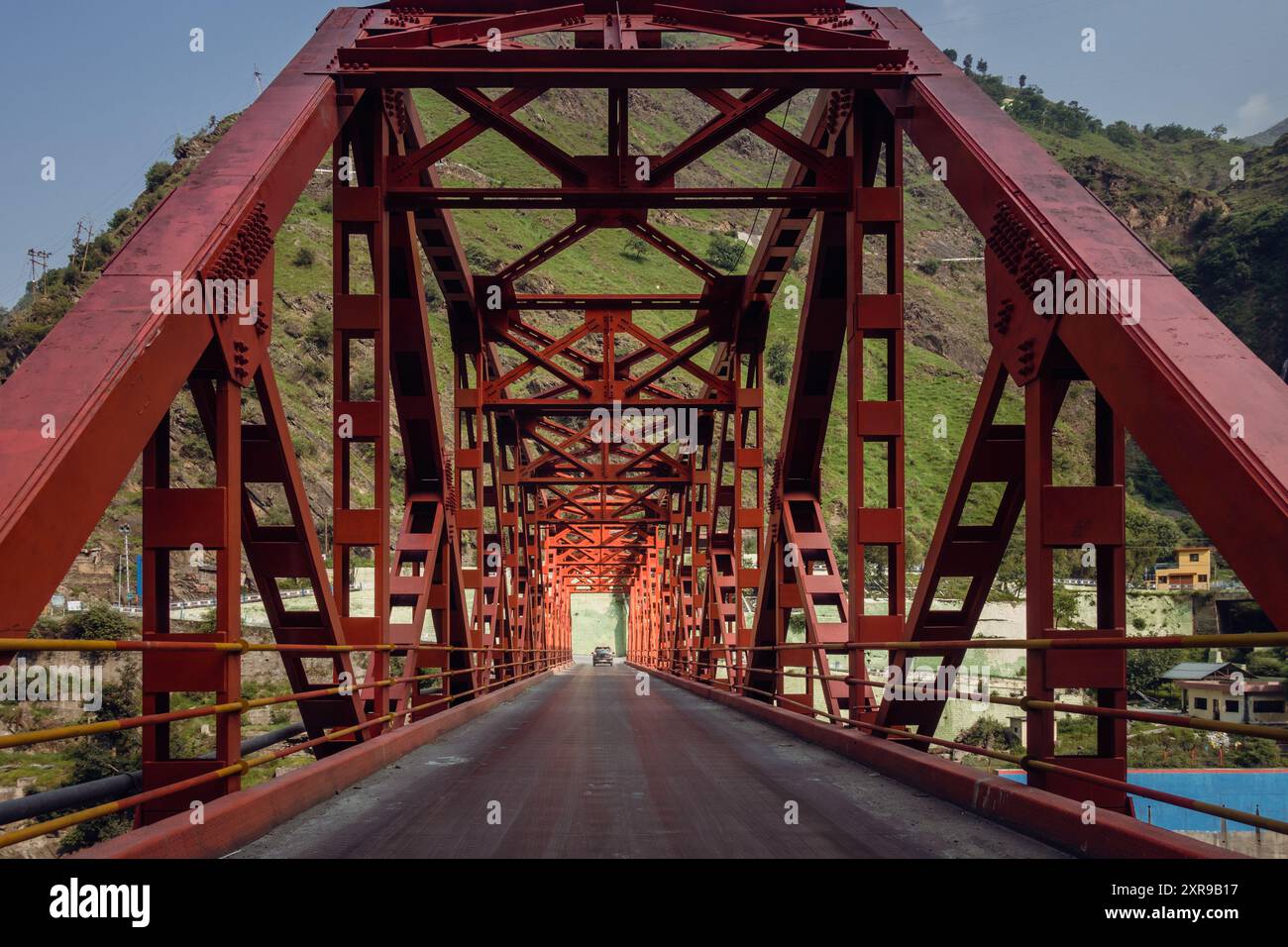 A striking red Truss Rod iron bridge spanning the Ravi River near the ...
